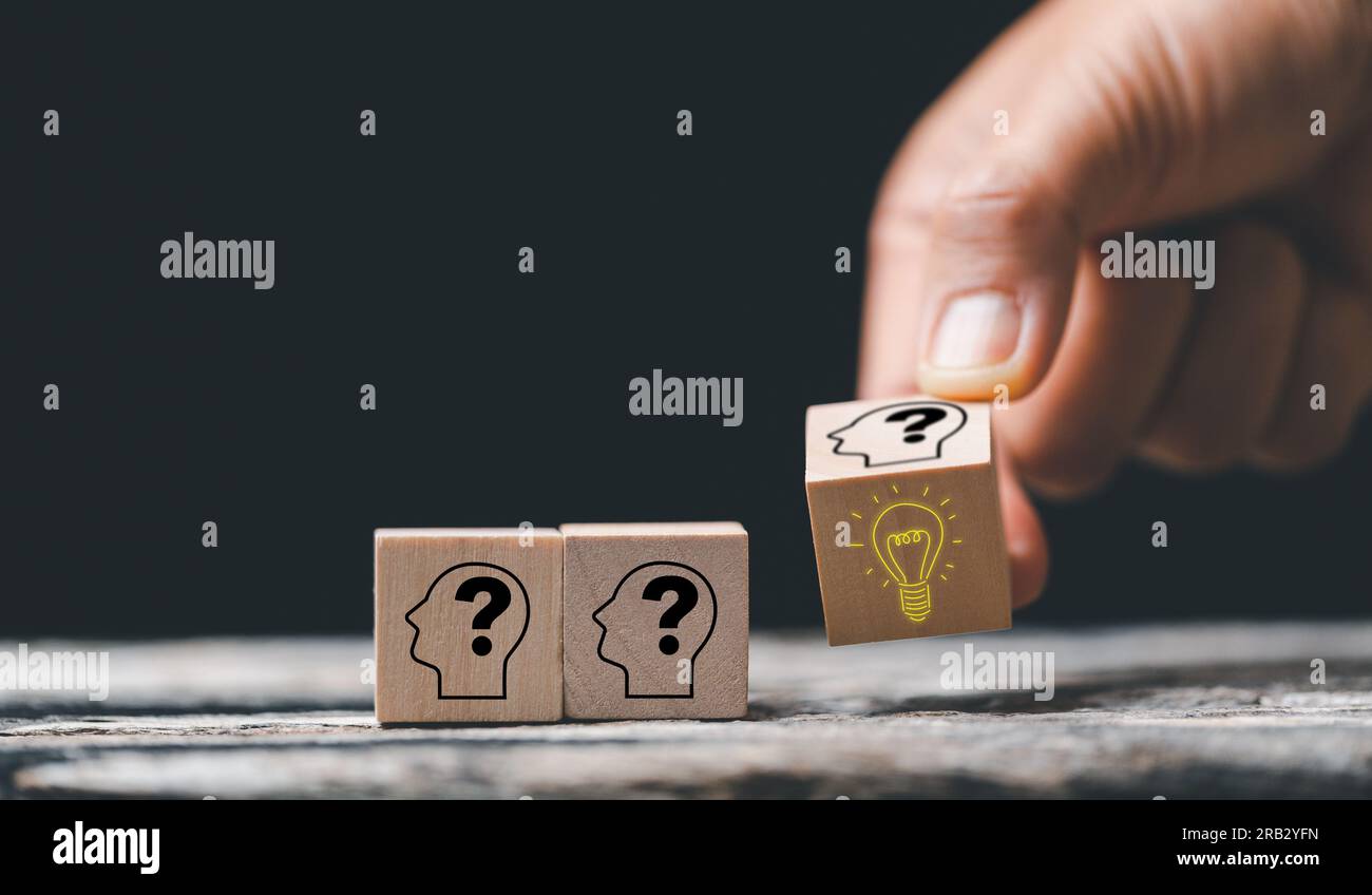 Concept creative idea and innovation. Hand choose wooden cube block with head human symbol and ...
