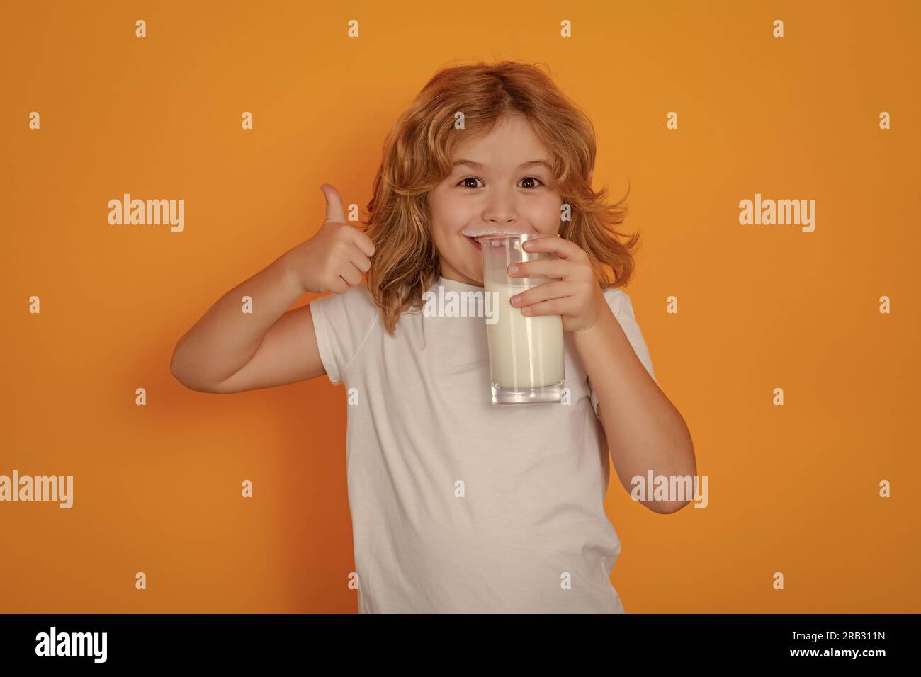 Dairy milk. Child with a glass of milk. Cute boy in white shirt holding ...