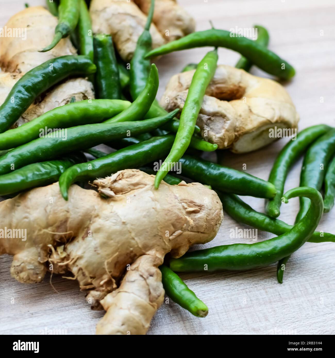 Fresh Ginger and green chili pepper on plain wooden table, green ...