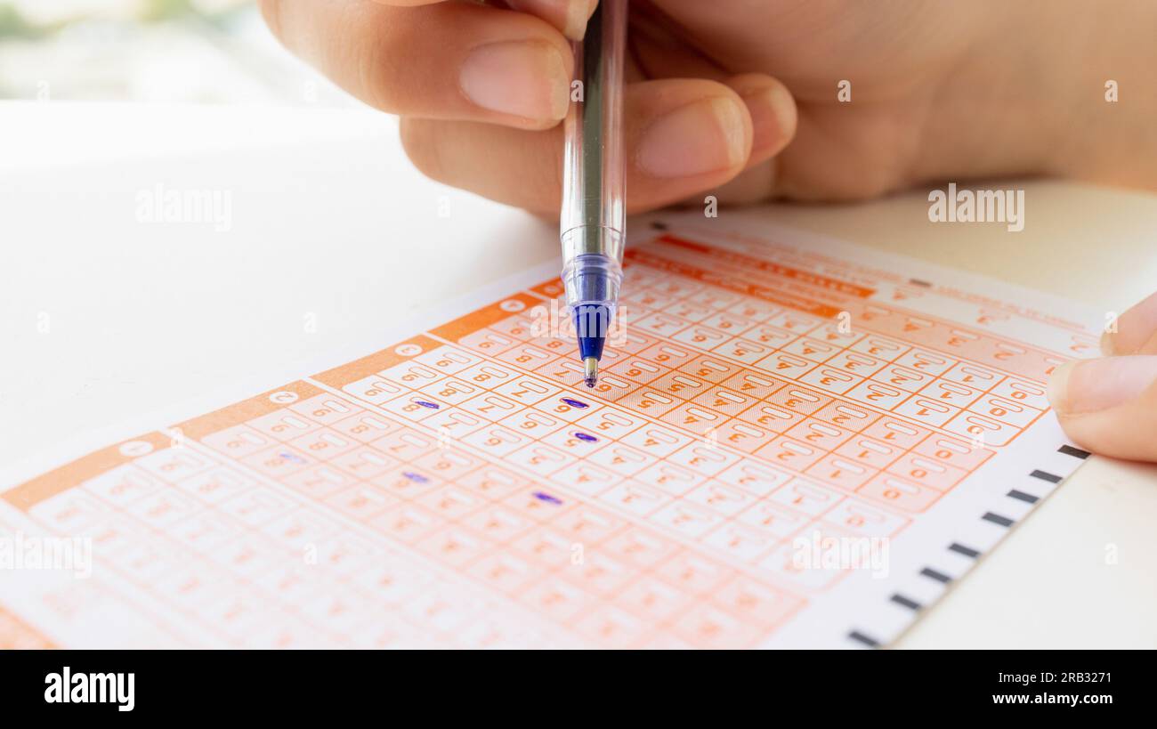 Woman hand marking numbers on Lottery Ticket with Pencil Stock Photo ...