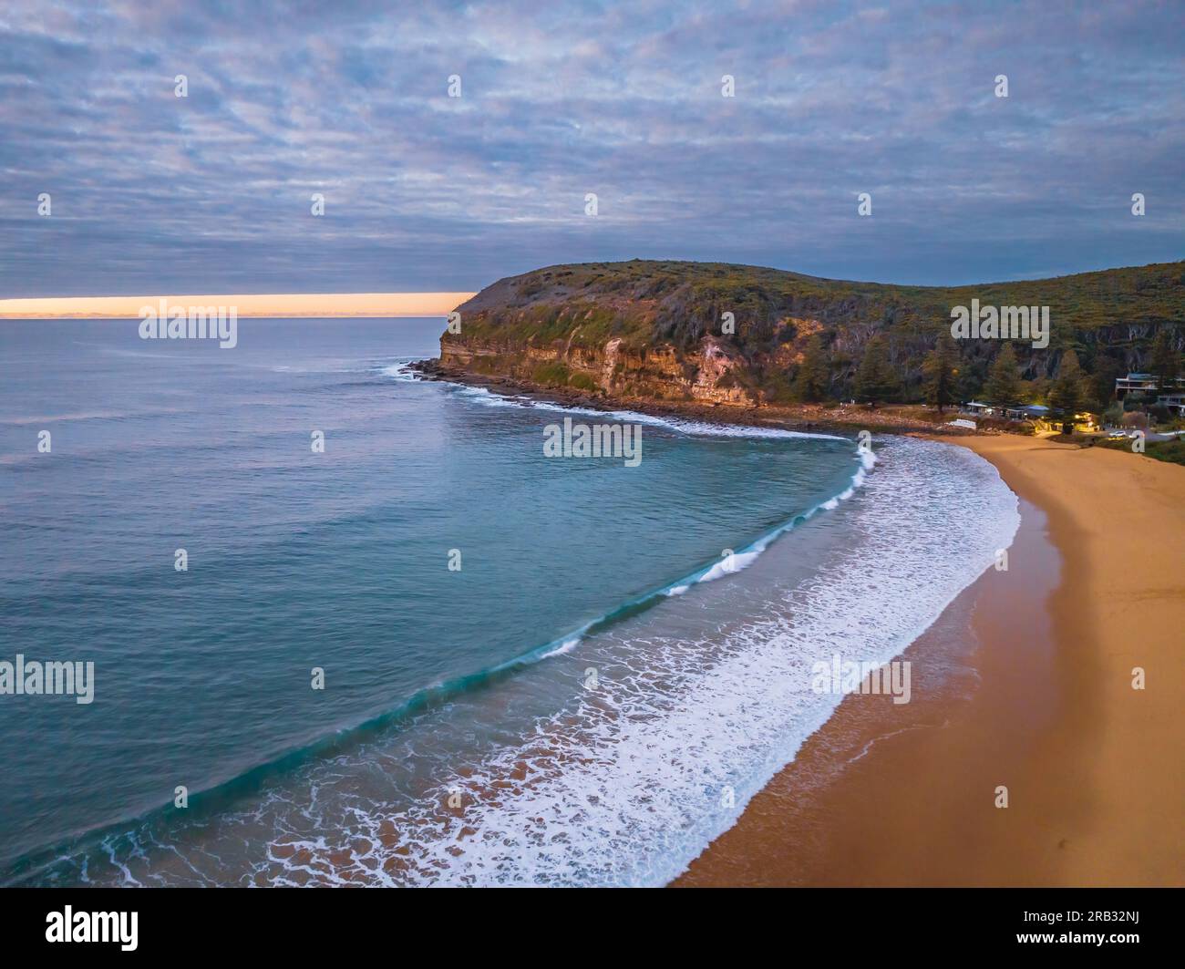 Aerial sunrise with cloud filled sky and small waves at Macmasters ...