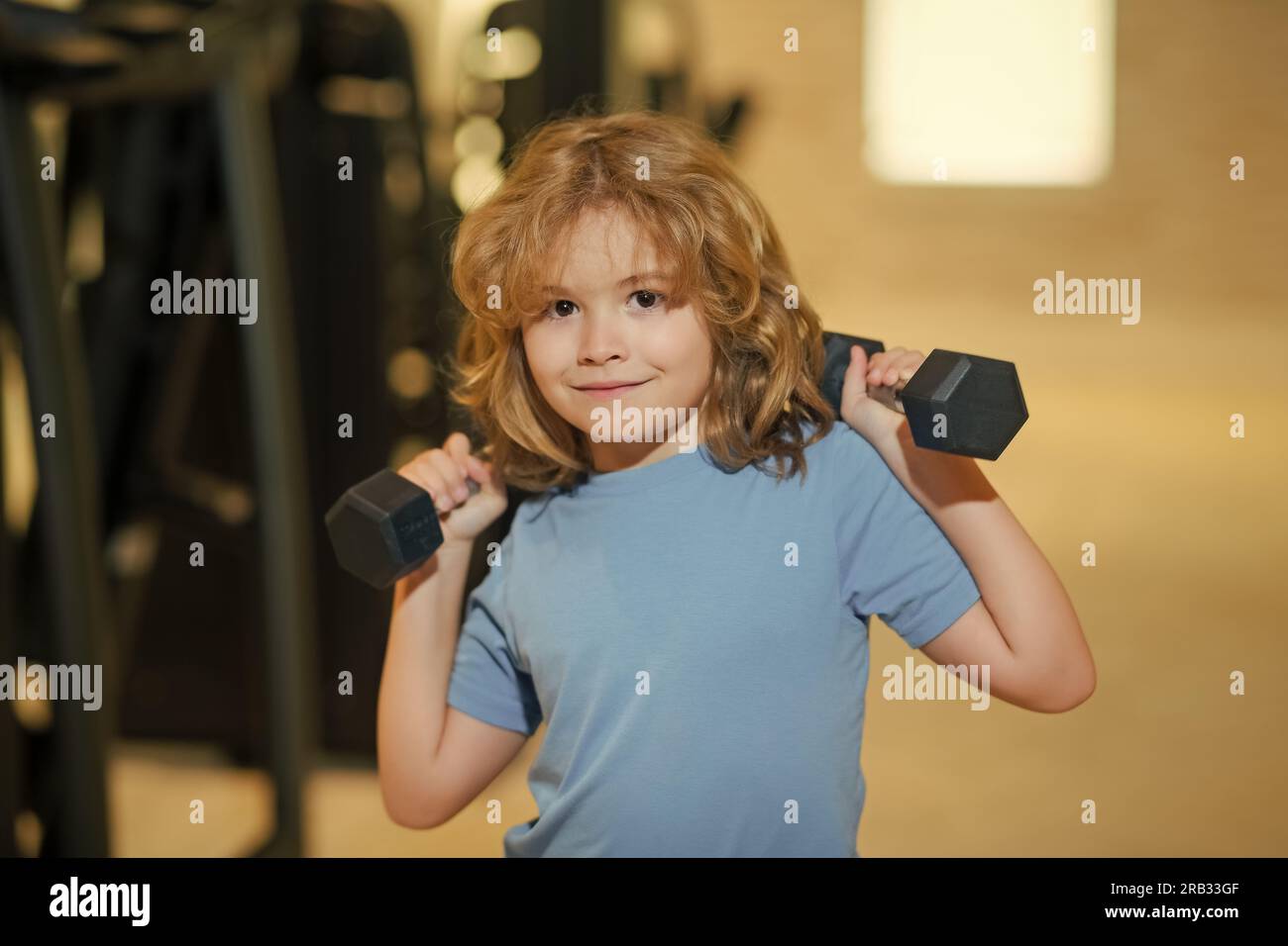 Sport activities at leisure with children. Boy holding dumbbells Stock ...