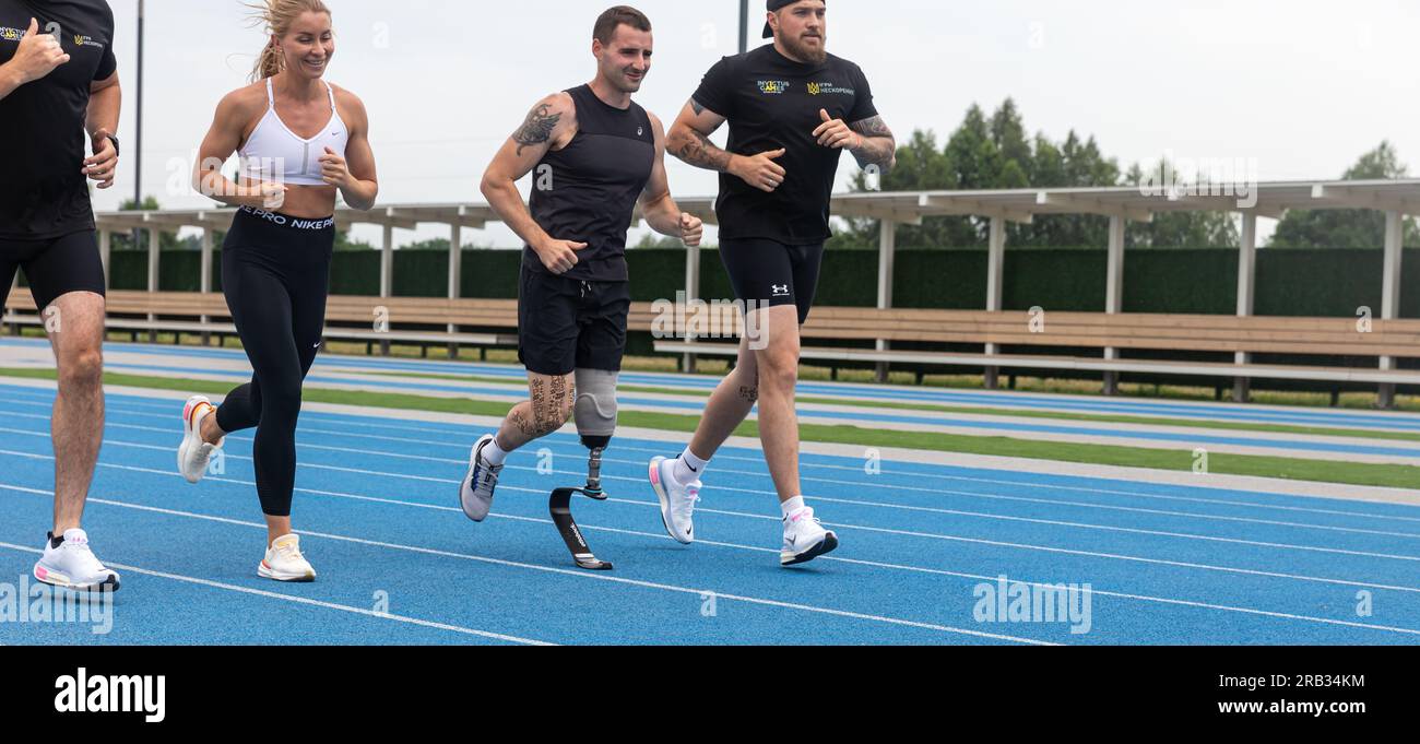 An athlete with a prosthetic leg is seen running in a group on a ...