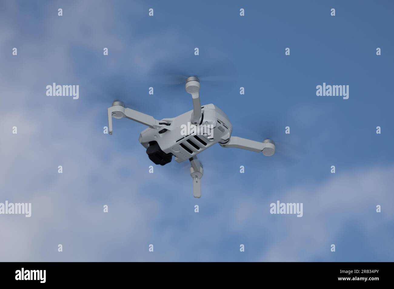 drone quadcopter with propellers uprated camera flying in blue sky ...