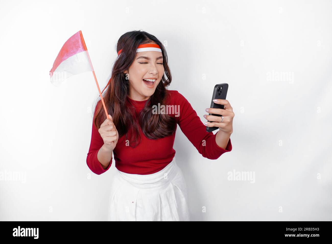 A Happy Asian Woman Wearing Headband Holding Her Phone And Indonesian