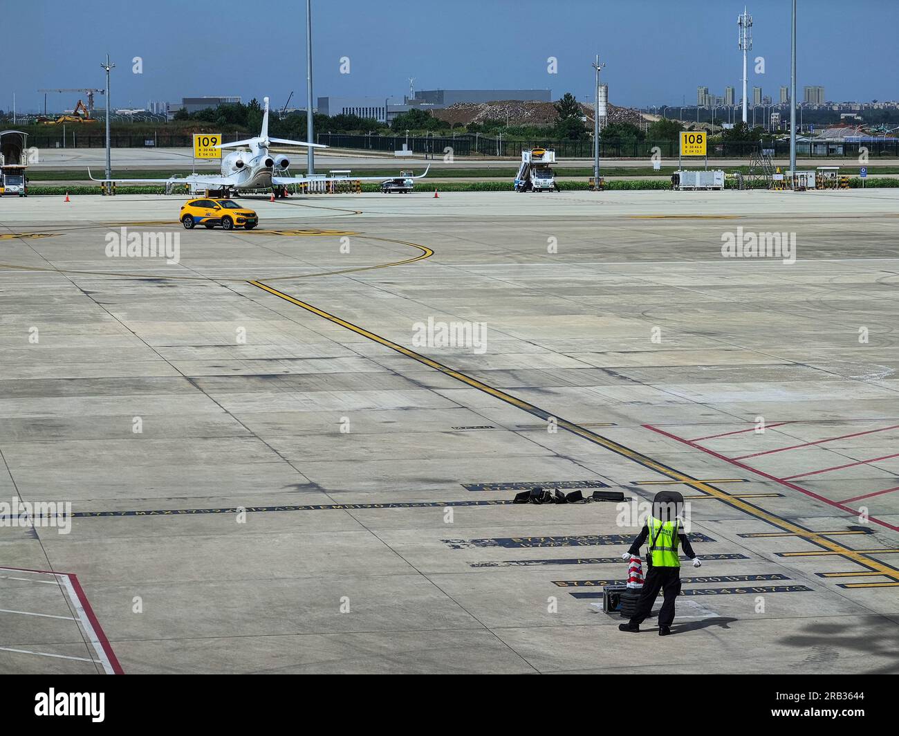 Airport ground guide waiting for a landing plane on the apron Stock ...