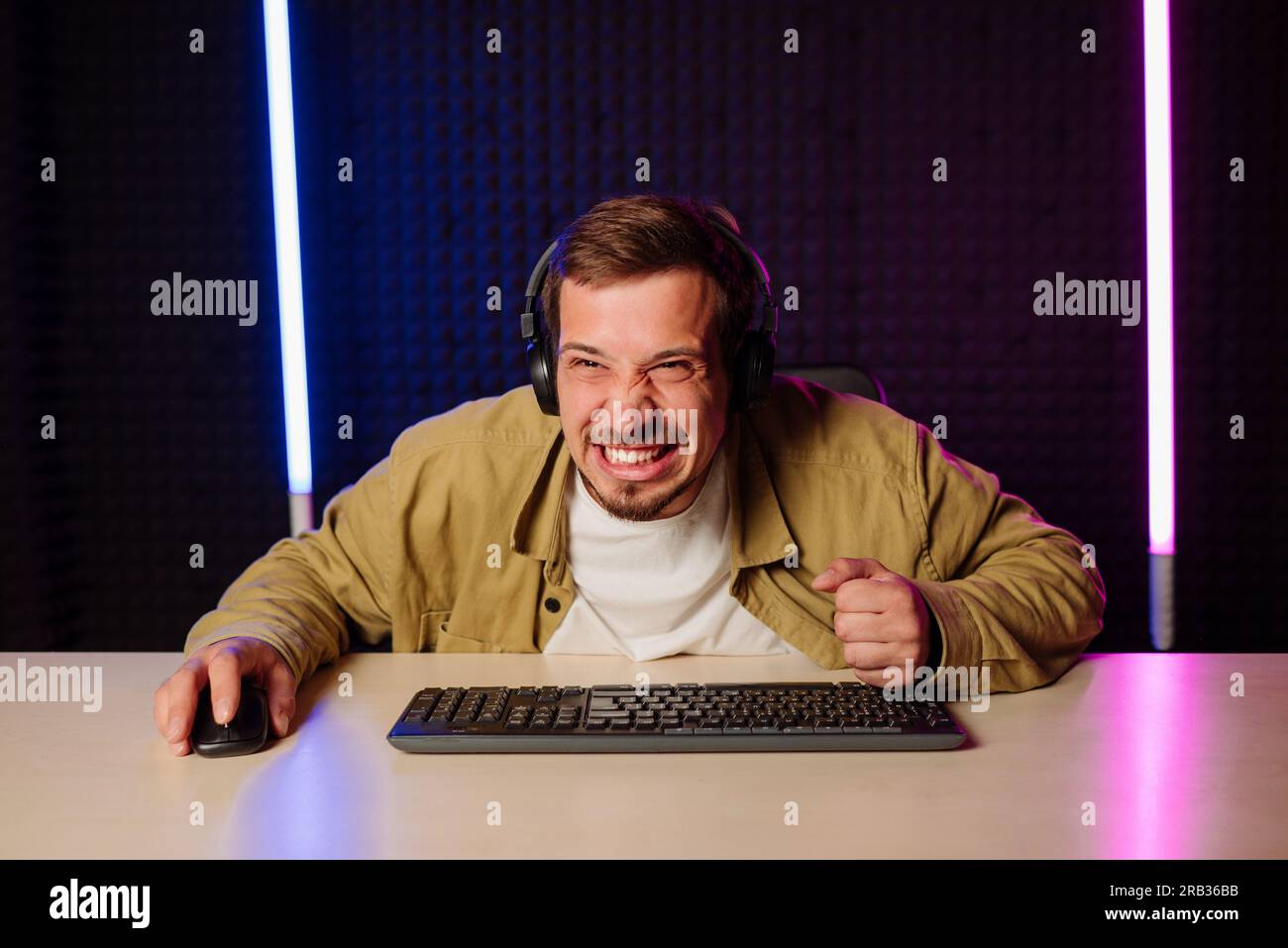 Emotional young gamer rejoices in winning a video game with a smile on ...