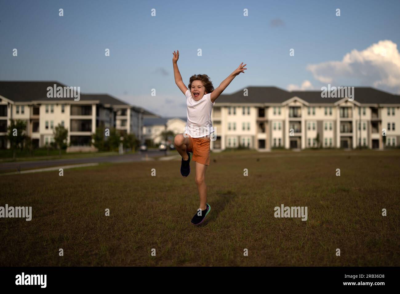 Excited amazed kid boy running on green grass background. Little ...