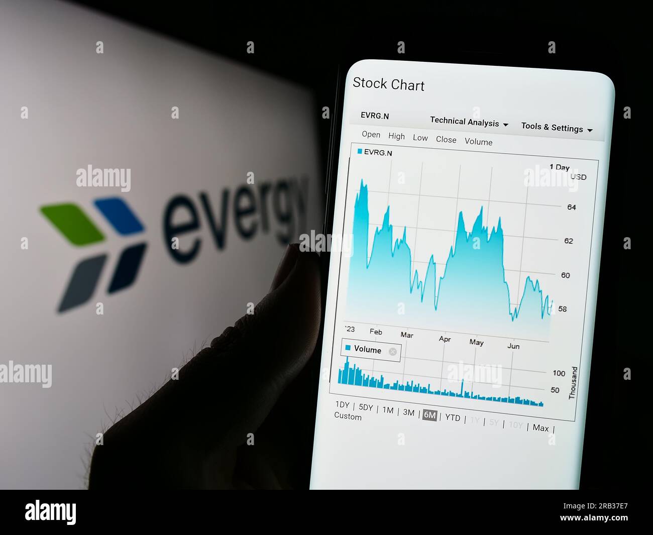 Person holding cellphone with website of US utility company Evergy Inc ...