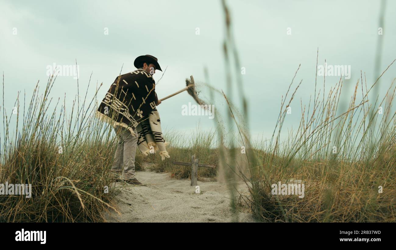 Cowboy digs a grave in the desert Stock Photo - Alamy