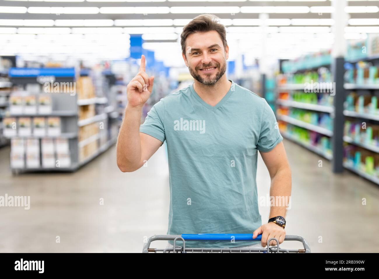 Portrait of hispanic man with shopping trolley purchasing in grocery ...