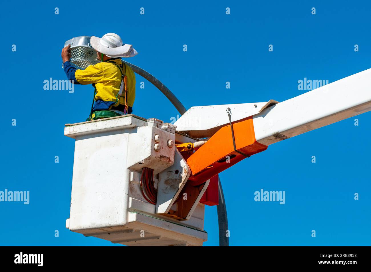 Workman replacing lamps in street lighting from a cherry picker Stock ...
