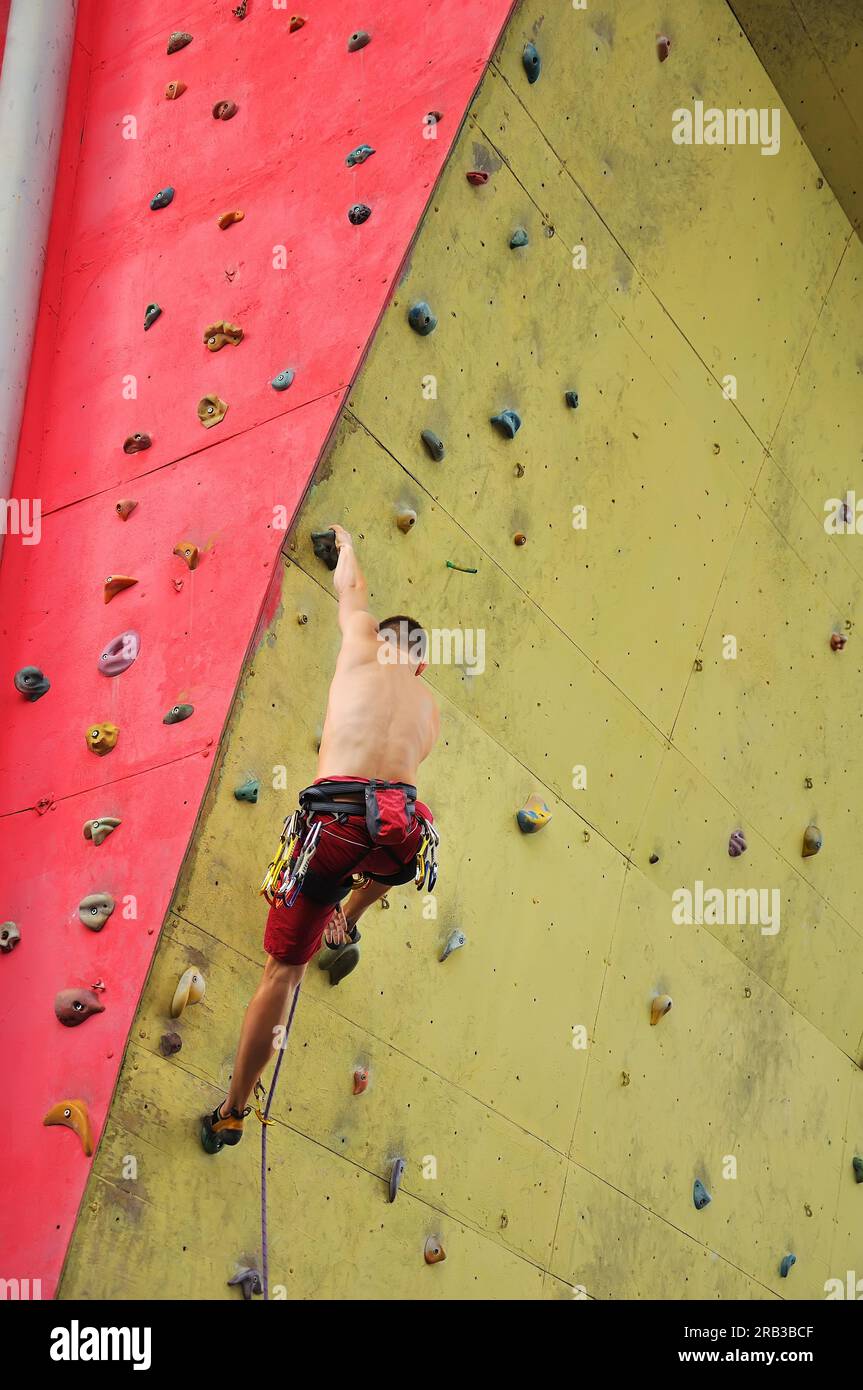 Muscular man climbing on a big wall Stock Photo - Alamy
