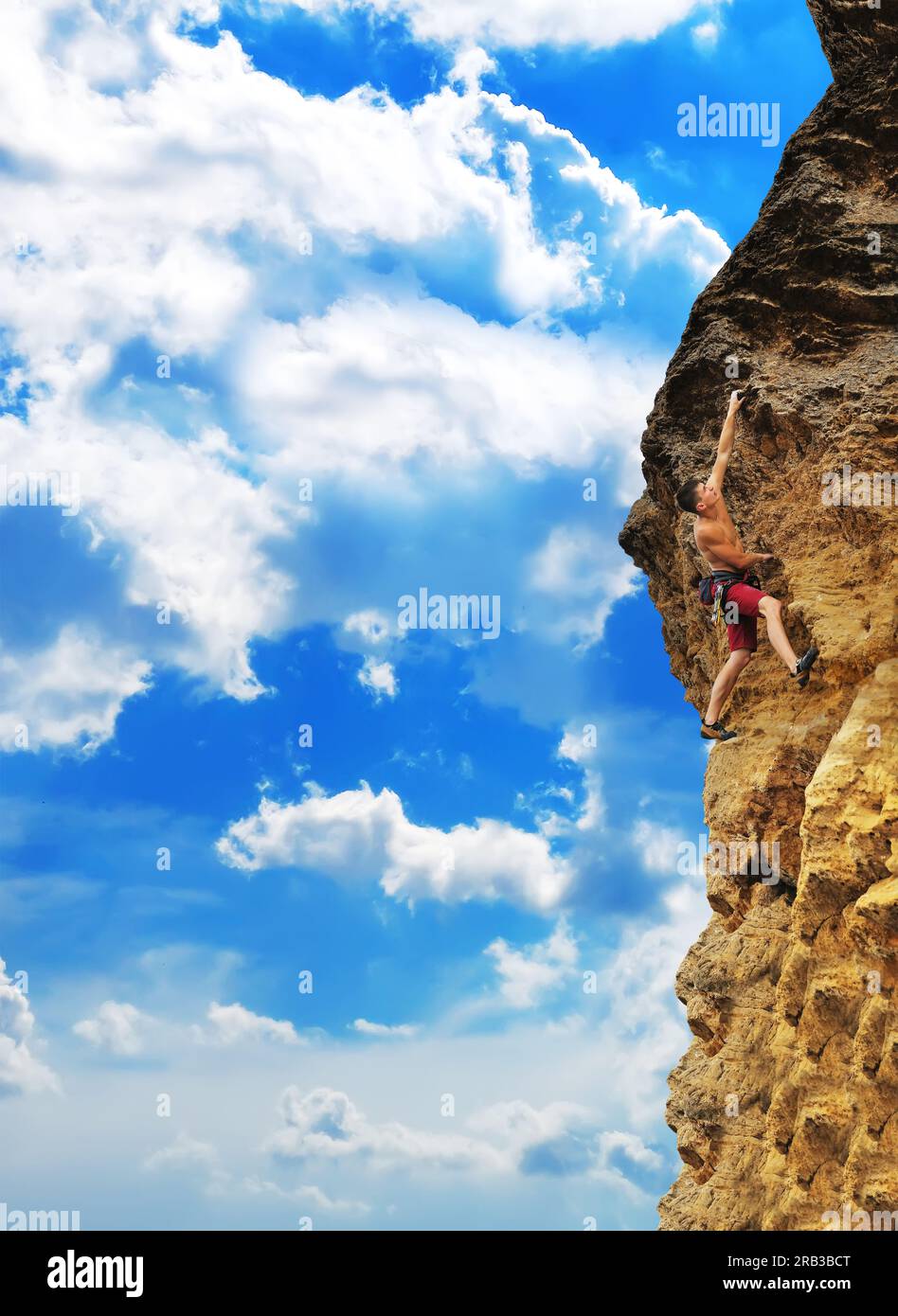 Muscular man climbing on rock Stock Photo - Alamy