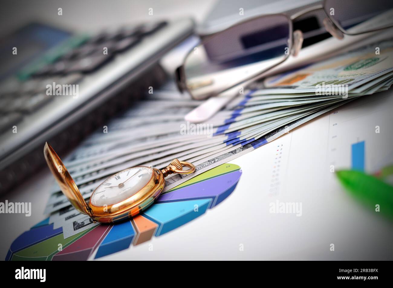 business charts, dollars and antique gold pocket watch on table Stock ...