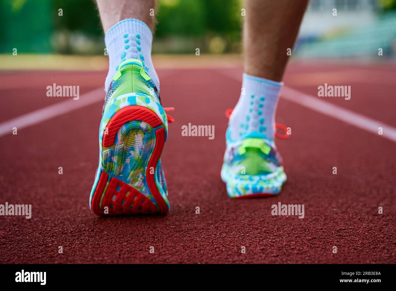 Male sportsman wearing running shoes at stadium track preparing to ...