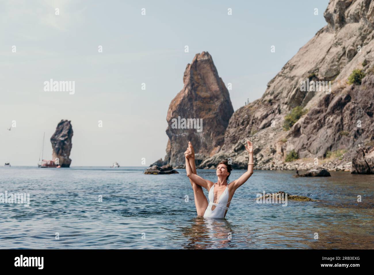 Woman sea fitness. Happy woman in a white bikini performing pilates in ...