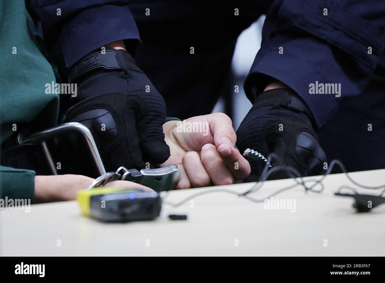 Itzehoe, Germany. 07th July, 2023. A court official opens the handcuffs ...