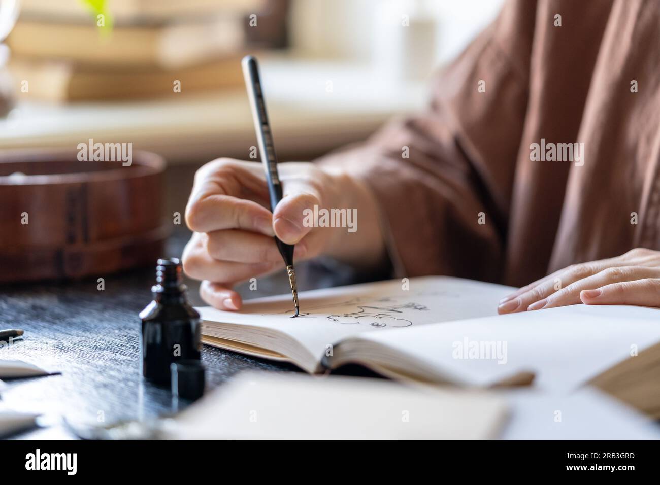 Illustrator freelancer holds fountain pen make sketch in notebook for ...