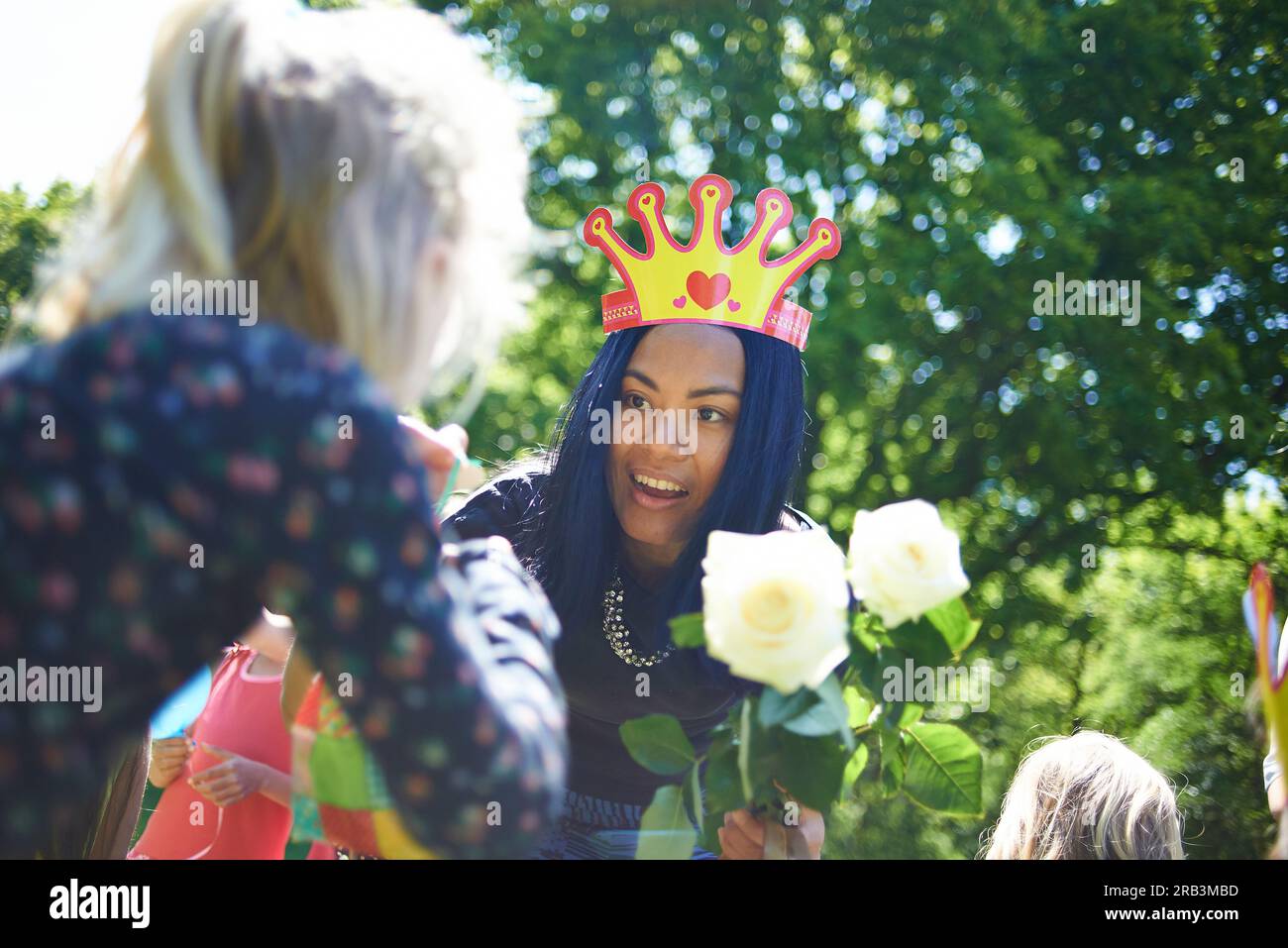 Asian woman wearing a tiara playing fairy princess at a kids party ...