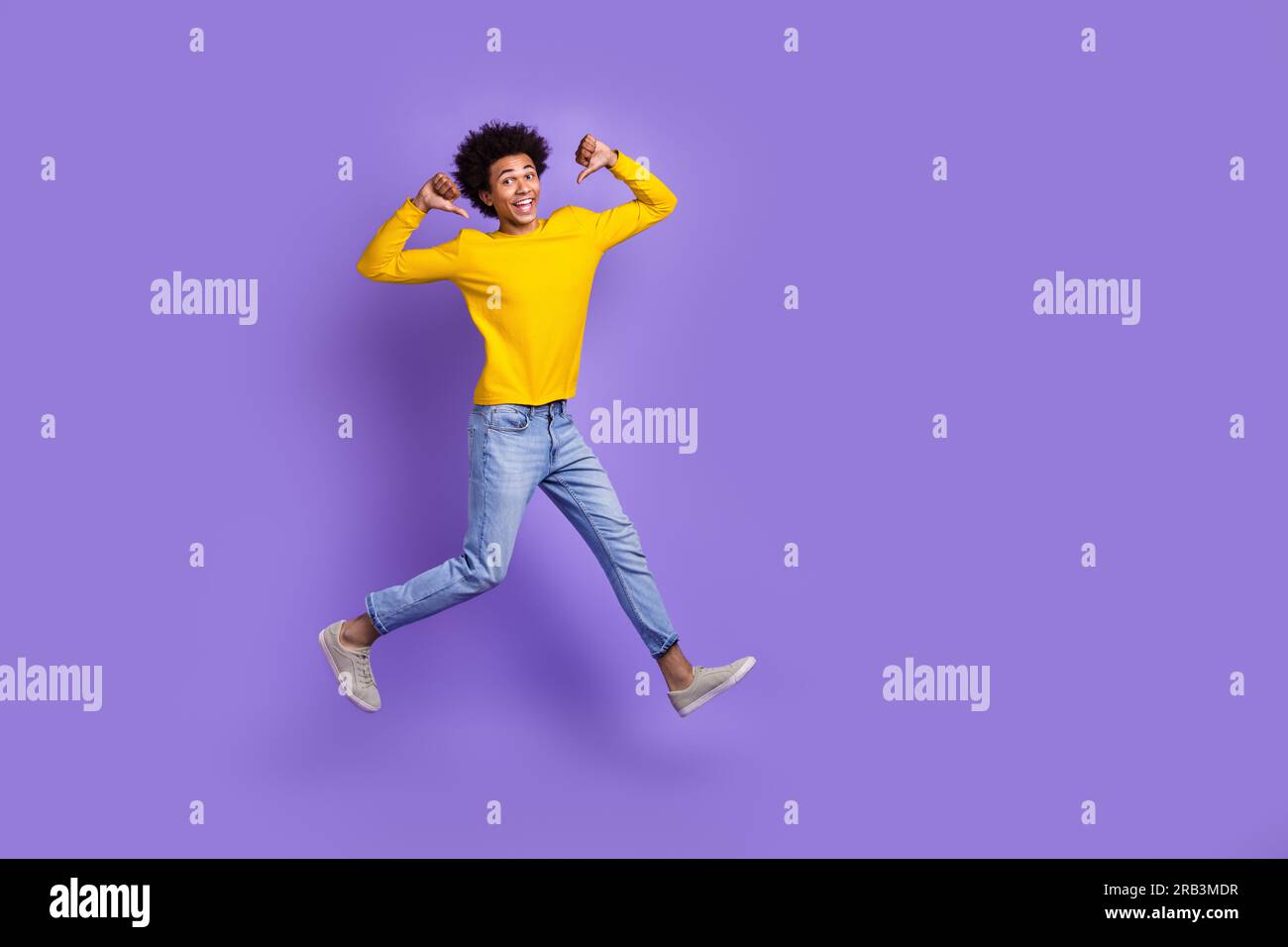 Full body size cadre of young man jumping directing fingers himself ...