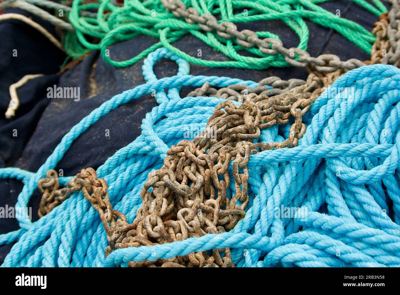 Heap of hawsers and chains laying in a fishing boat in a harbor in ...