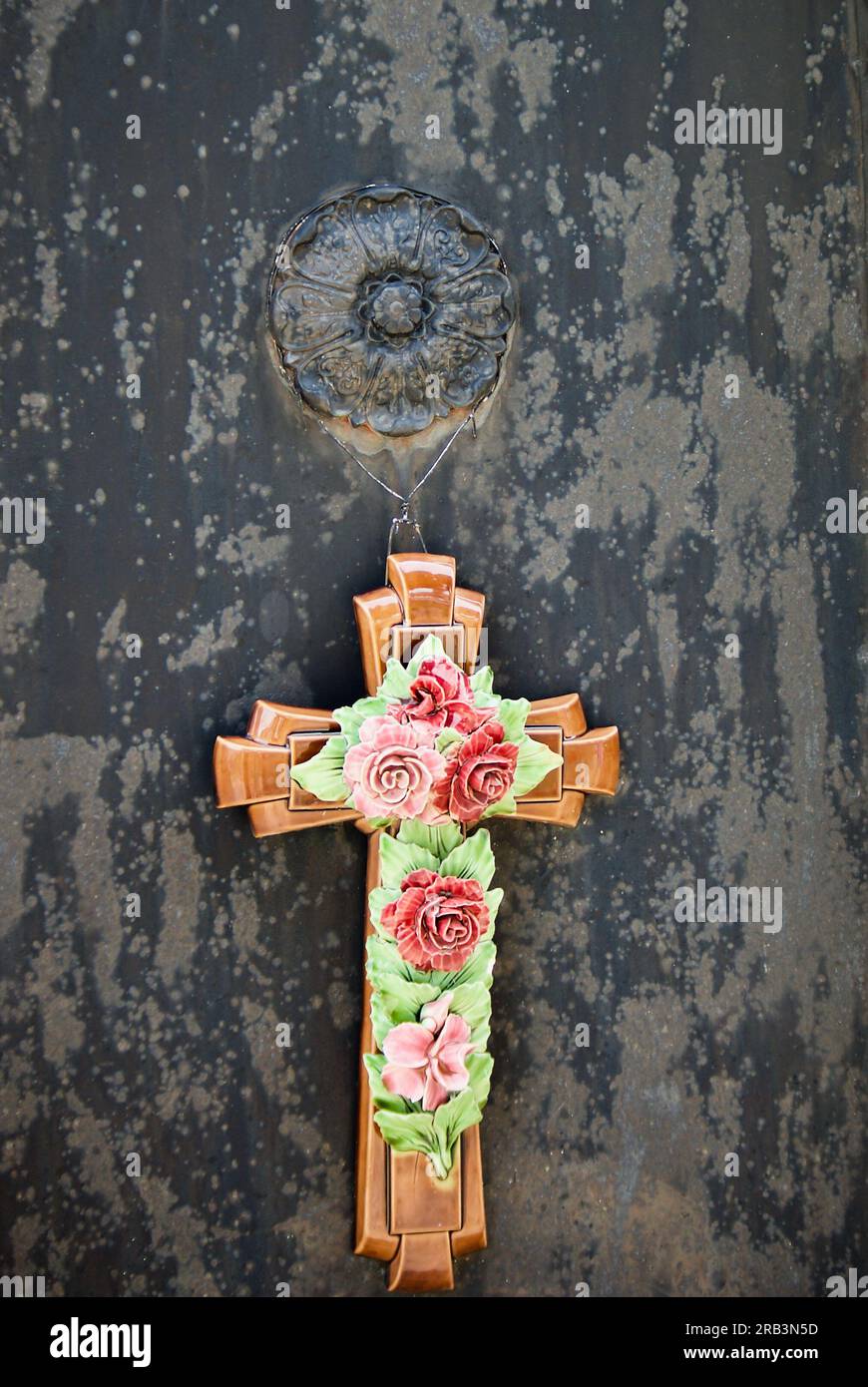 Small ceramic cross with flowers as decoration at a cemetery in France ...