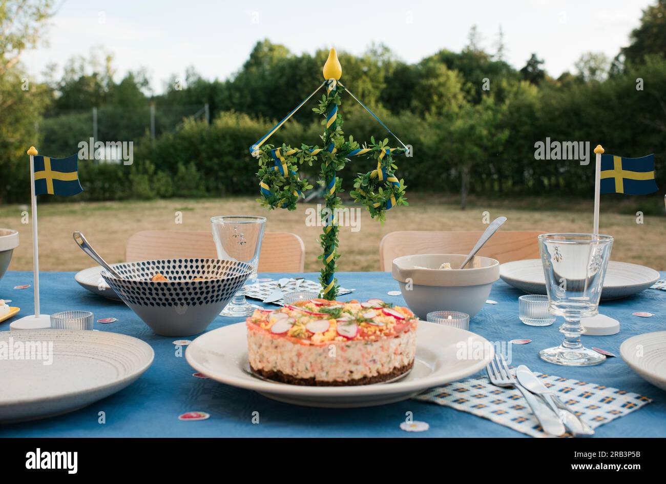 traditional Swedish food on an outdoor table celebrating midsummer ...