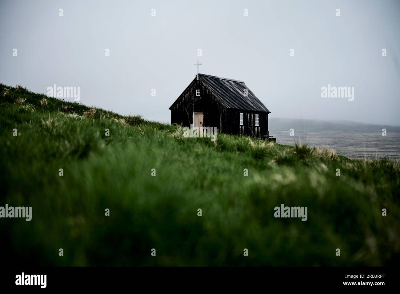 Small black church located on grassy slope Stock Photo - Alamy