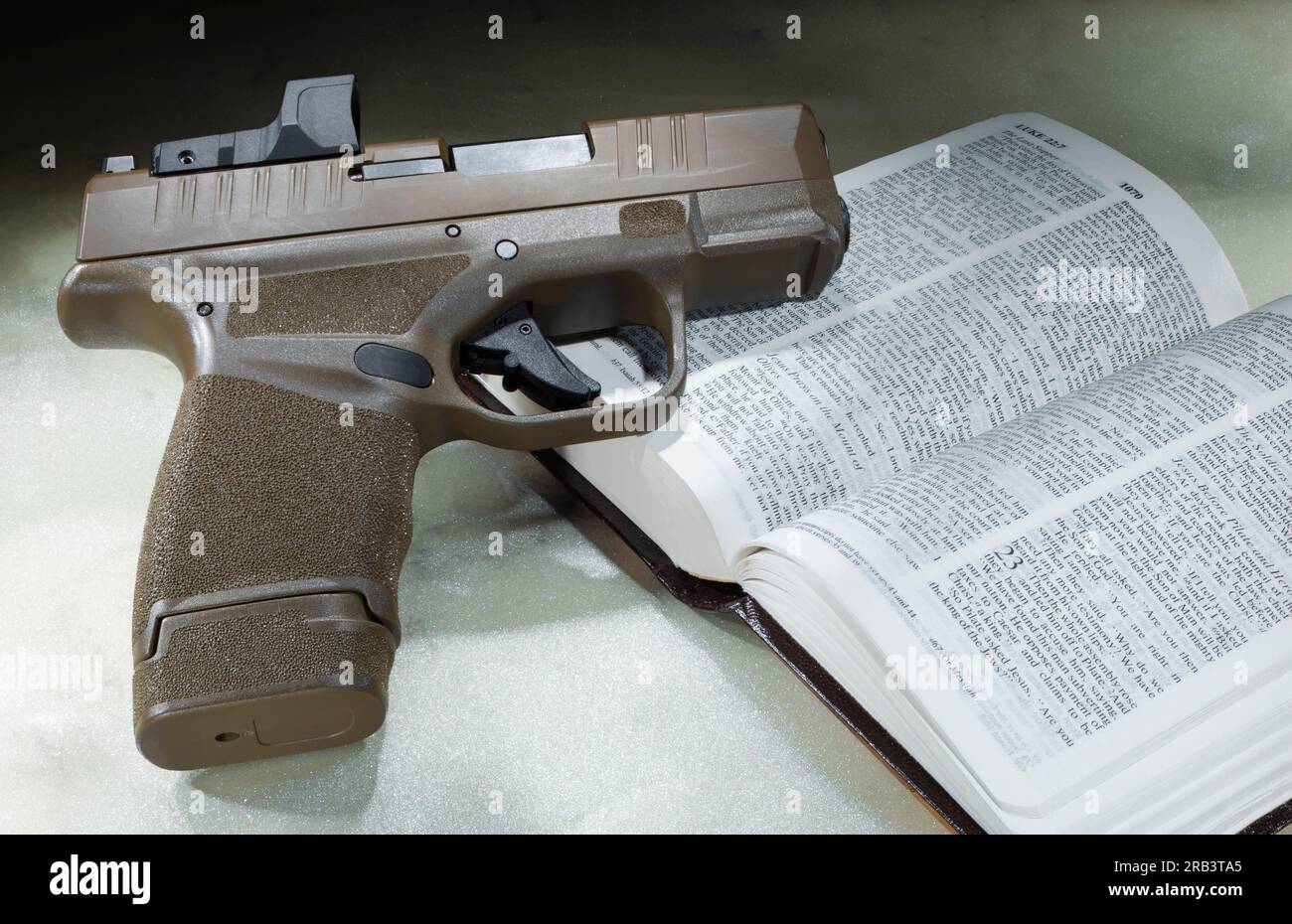 8 mm pistol that is loaded on top of a bible open to the passage ...