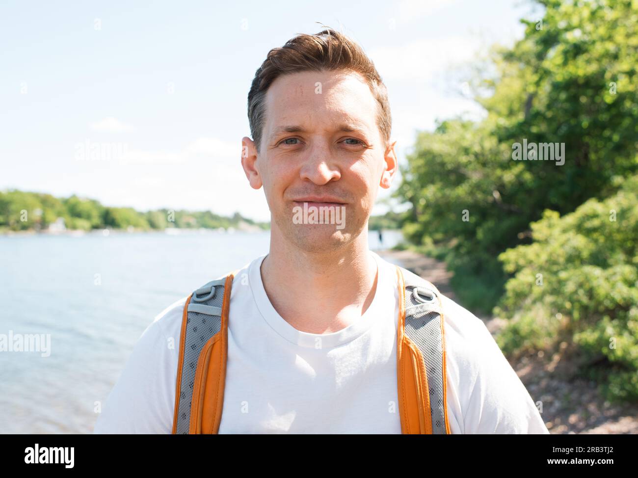 portrait of a man carrying a backpack whilst out walking Stock Photo ...