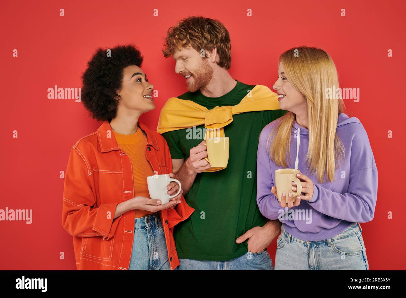 polyamorous concept, young multicultural women and redhead man holding ...