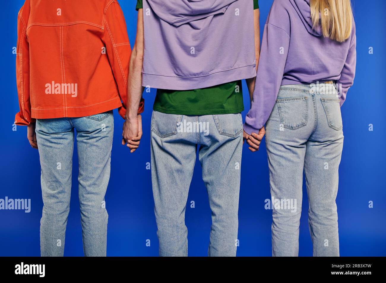 polygamy, back view of polyamory three people, young man and women ...