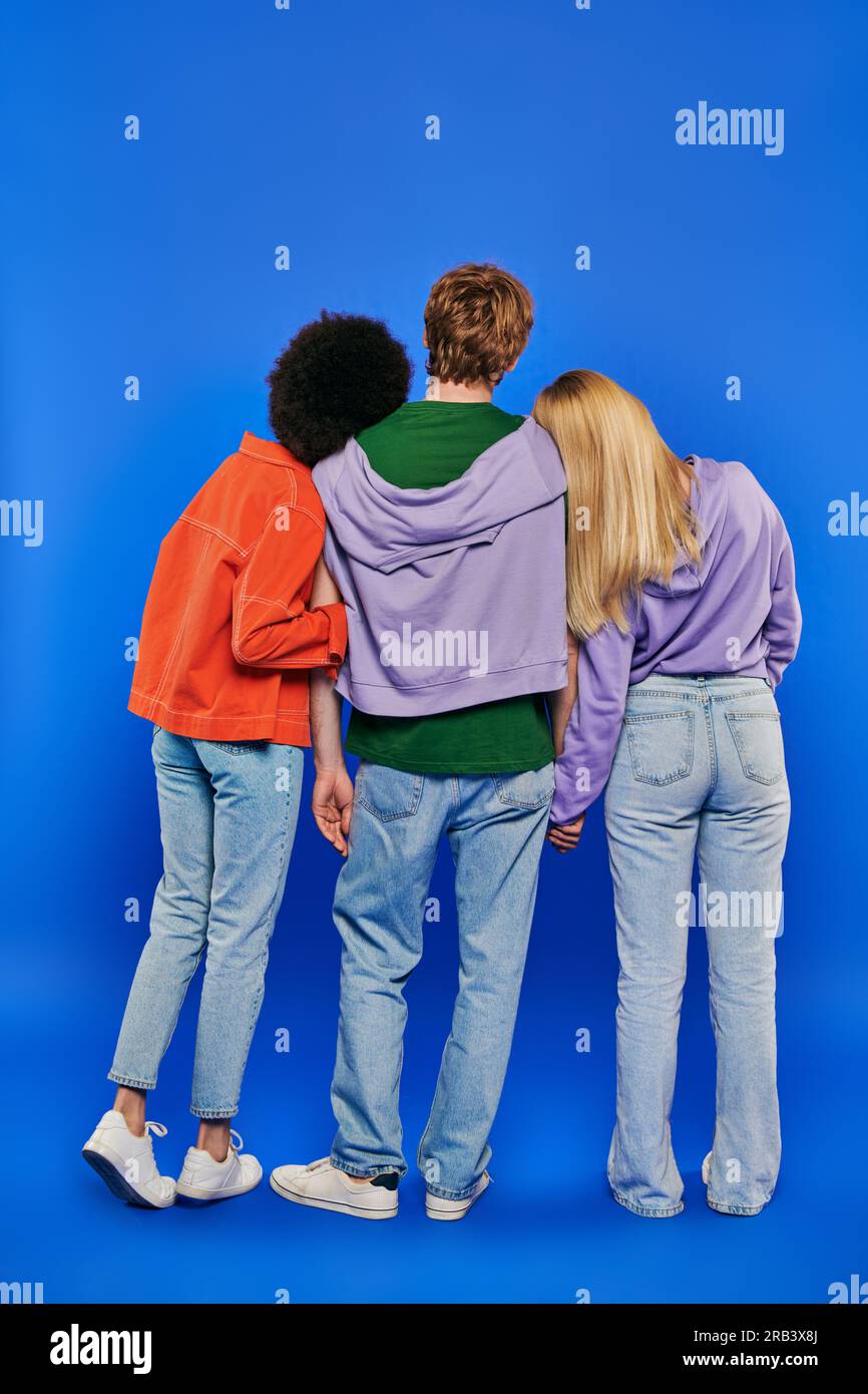 polygamy, back view of polyamory three people, young man and women ...