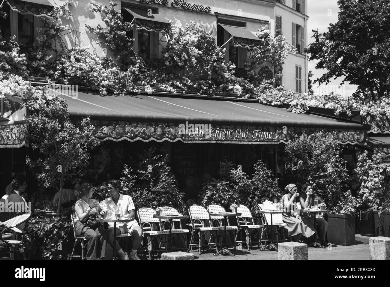 Paris, France - June 10, 2023: People enjoy food and drink at romantic ...