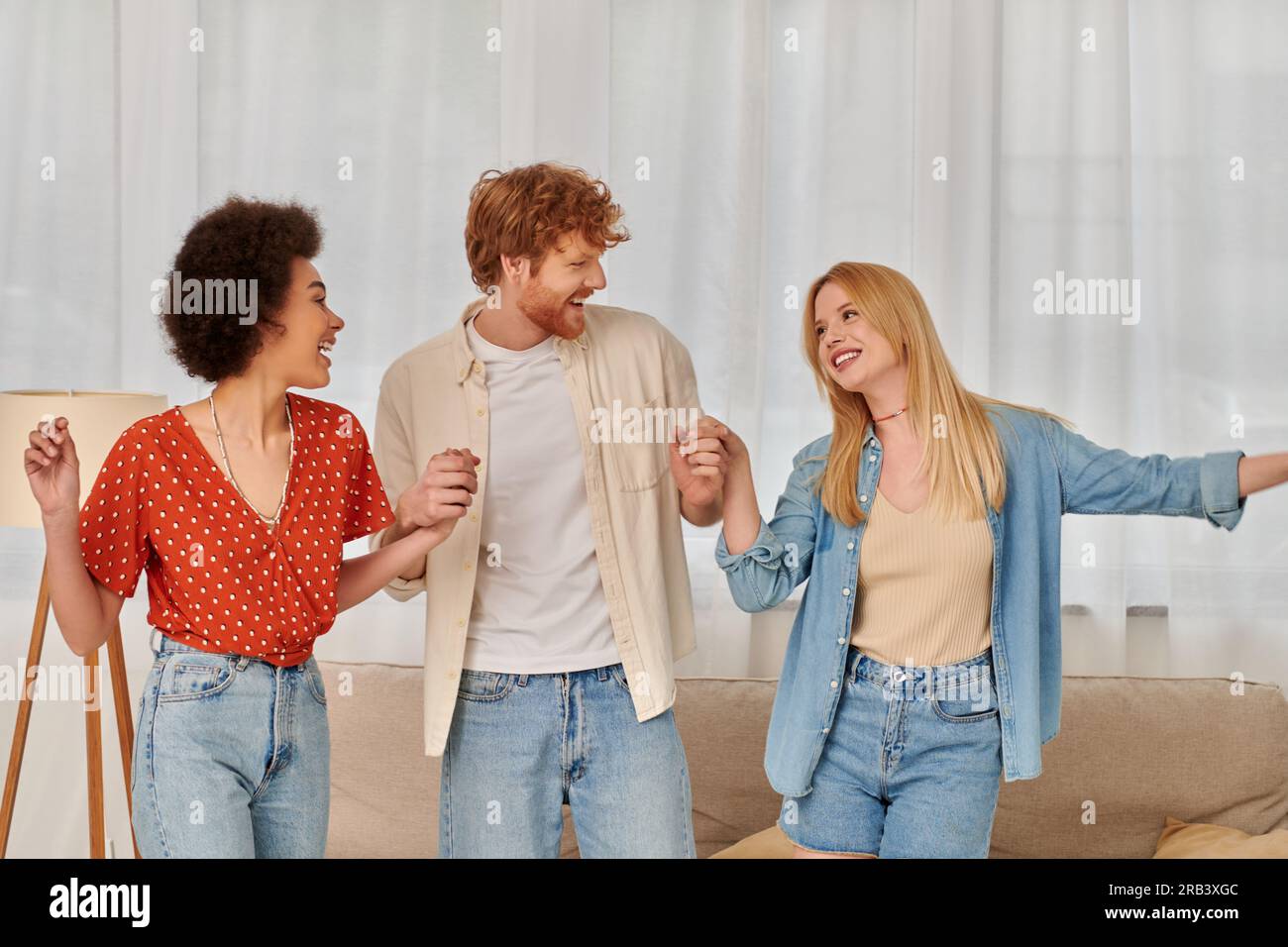 polyamorous concept, happy multicultural women and bearded man holding ...