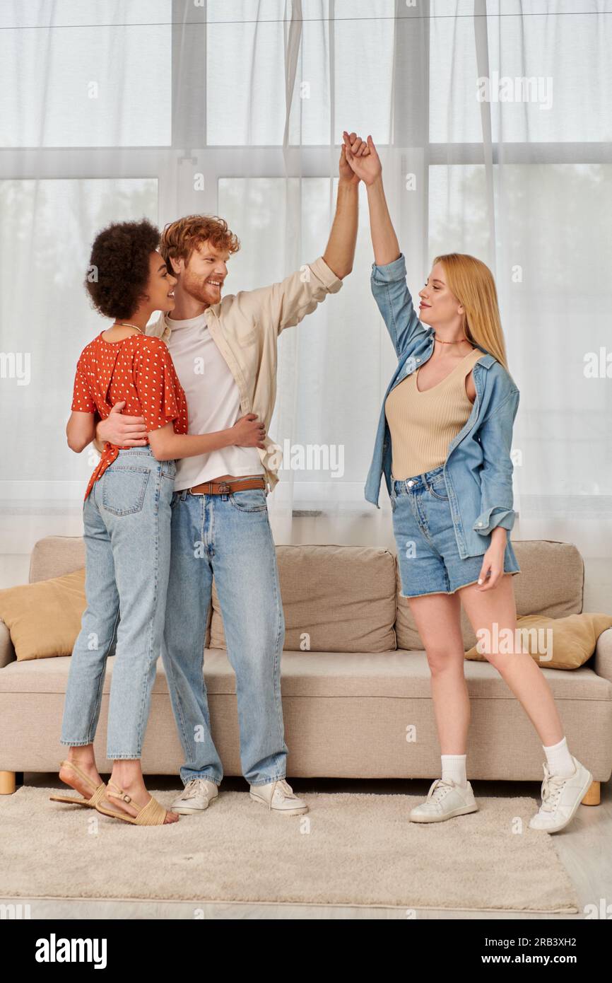 polygamy concept, lovers holding and raising hands while standing in ...