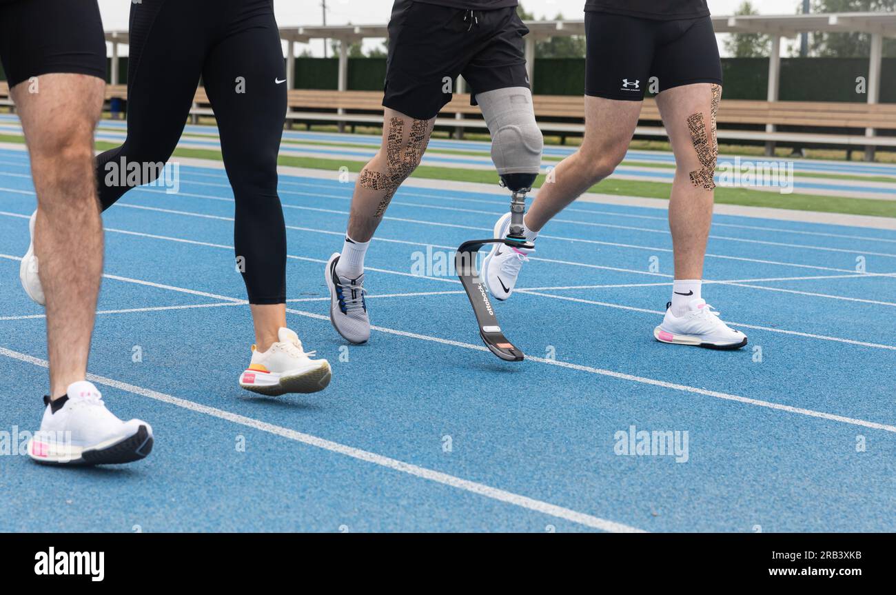 An athlete with a prosthetic leg seen running in a group on a running ...