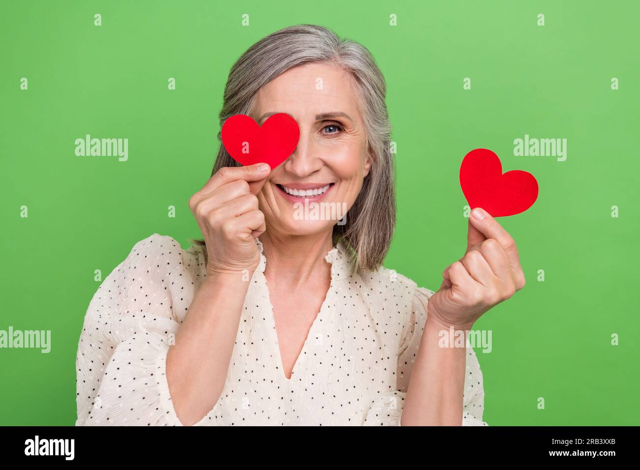 Photo portrait of beautiful grandma hold two little heart cards cover ...