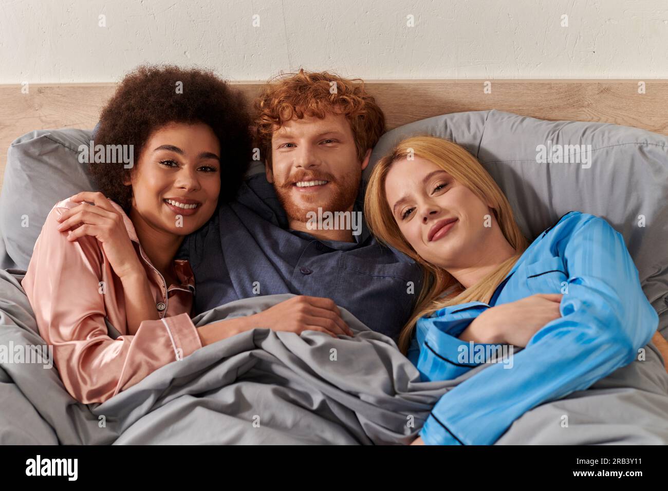 polygamy, alternative relationships, three adults, happy redhead man ...