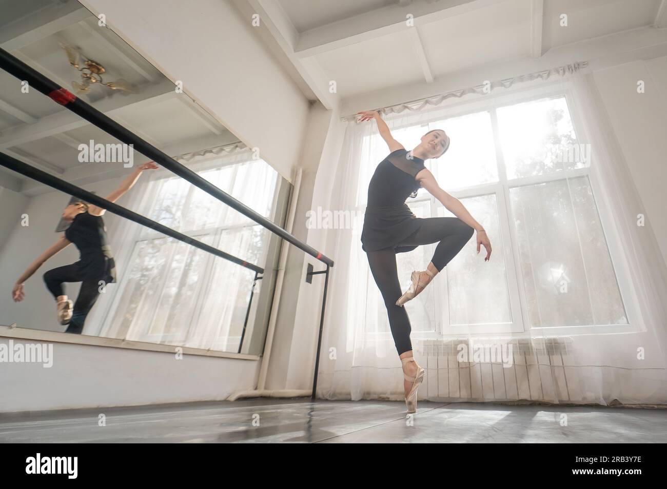A beautiful Asian woman is dancing at the barre. Ballet dancer Stock ...