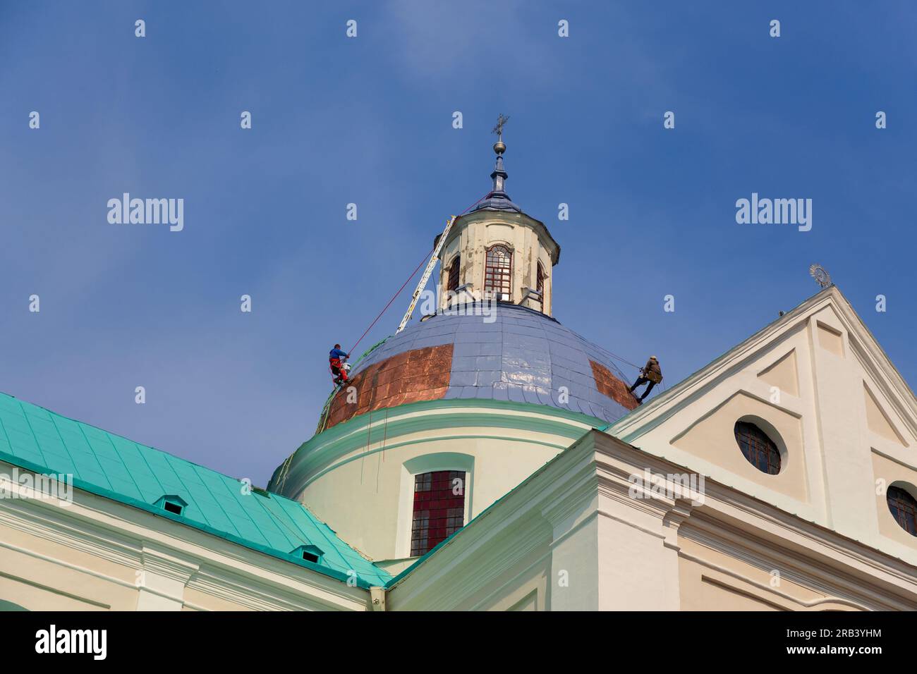 Workers perform work to replace the roof in the Catholic Church. This ...