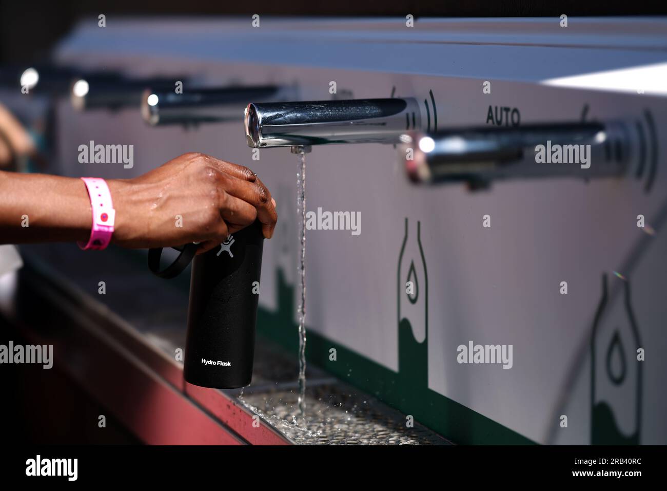 People refill their bottles with water on day five of the 2023 ...