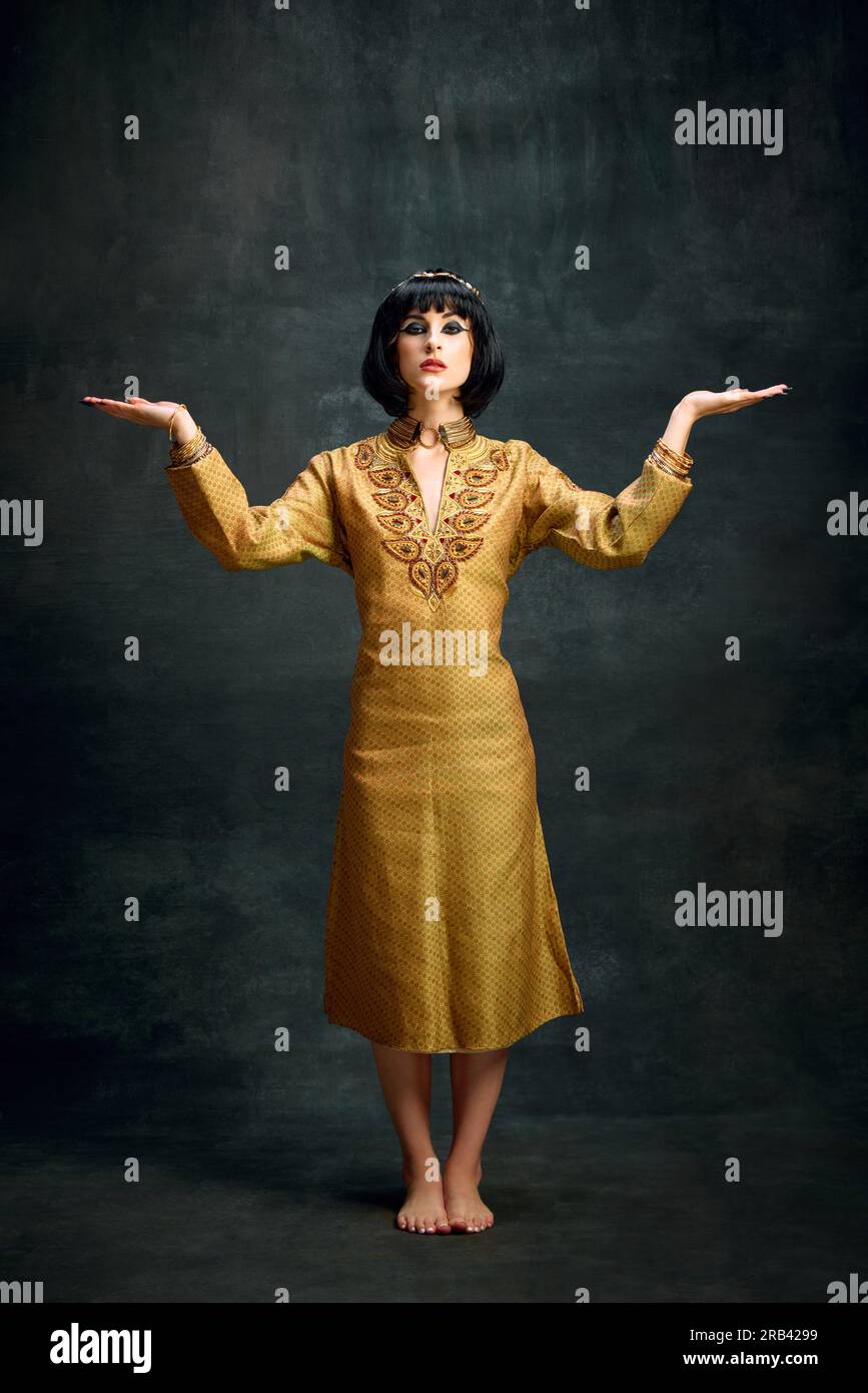 Portrait of young woman in golden dress, egyptian queen Cleopatra ...