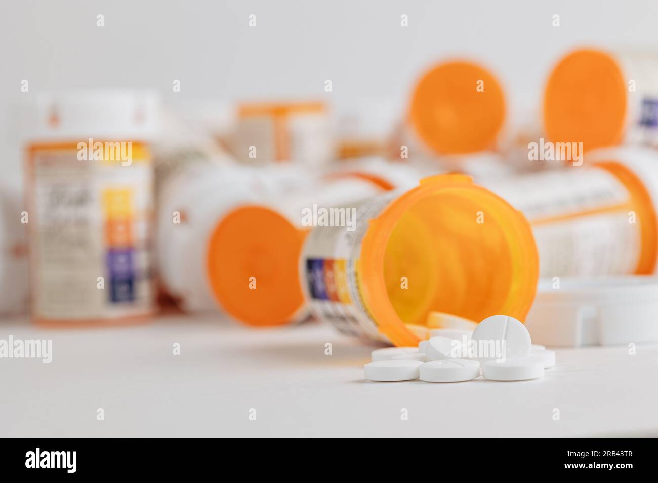 A bunch of prescription pill bottles grouped on a table with white ...