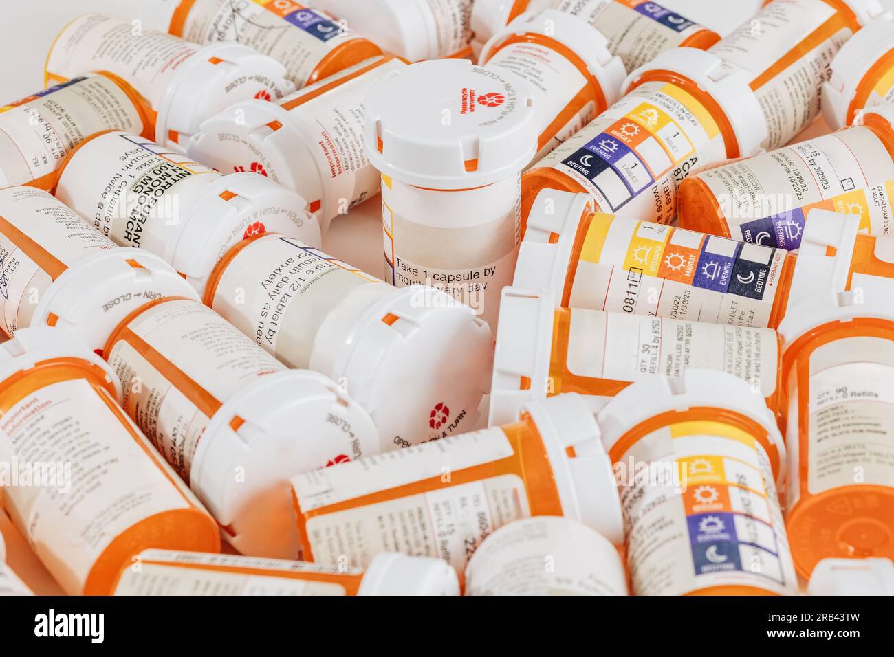 a pile of prescription pill bottles on white background with labels ...