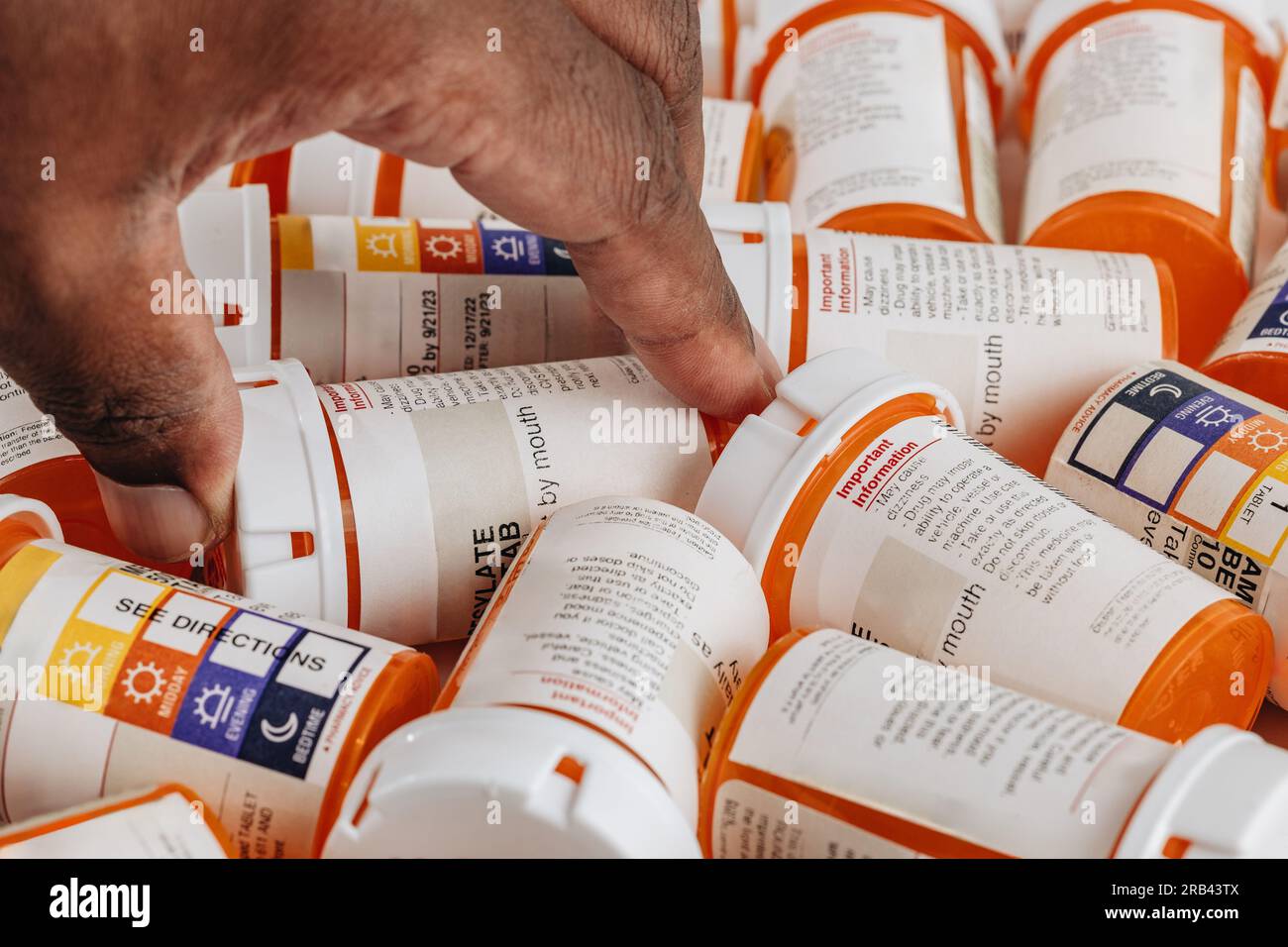 A bunch of prescription pill bottles grouped on a table with white ...