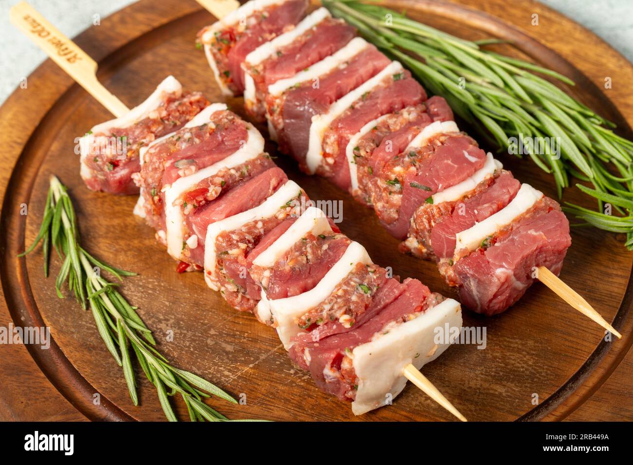 Beef skewer. Shish kebab prepared with raw ribeye and minced meat on a gray background Stock ...