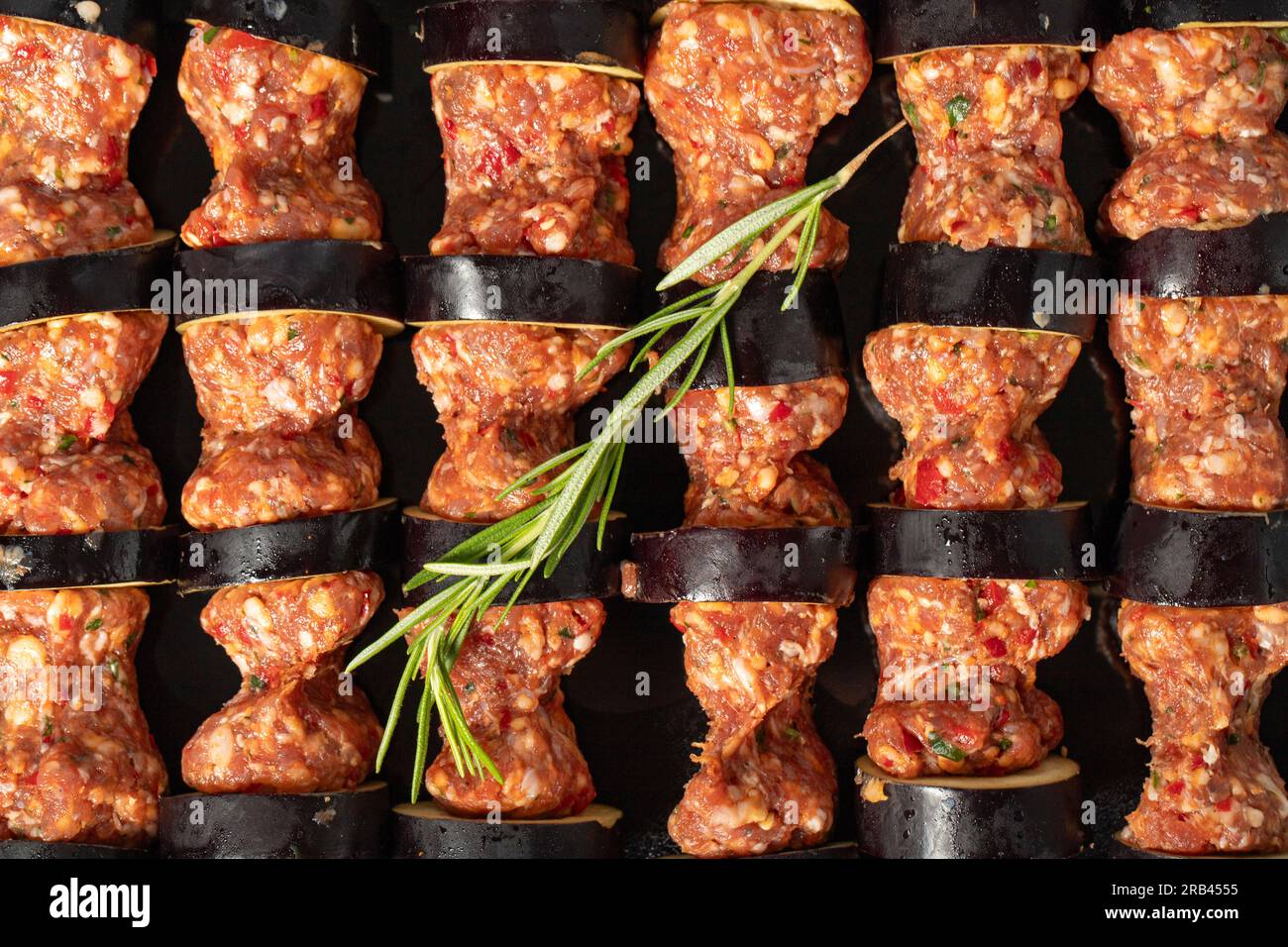 Eggplant kebab. Close-up of aubergine shish kebab with raw minced meat ...