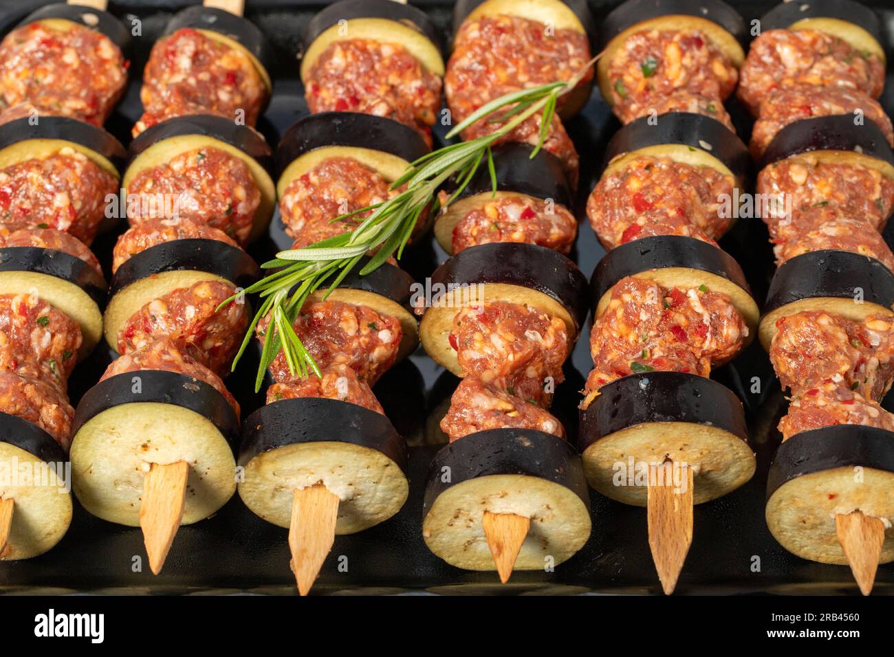 Eggplant kebab. Close-up of aubergine shish kebab with raw minced meat ...